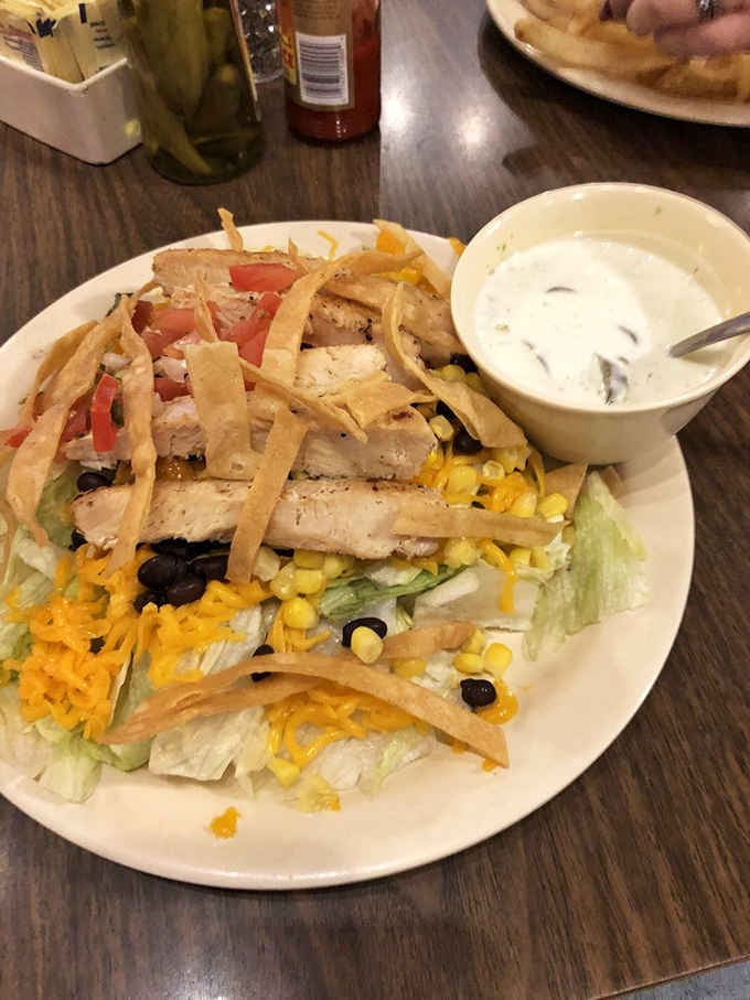 Fresh salad topped with grilled chicken strips and crispy tortilla strips, for those rare moments when you pretend to eat healthy.