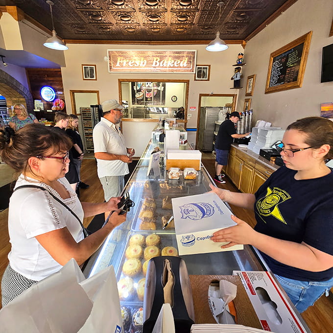 Fresh-baked goods meet eager customers at a counter where service comes with genuine small-town warmth and efficiency.