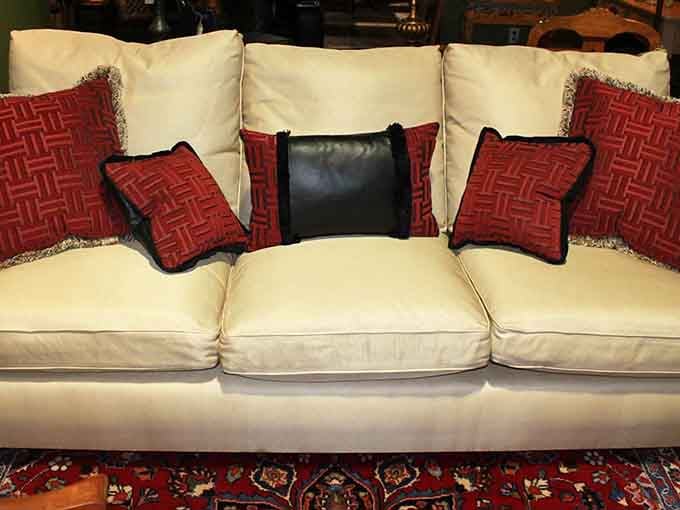 A cream sofa adorned with geometric red pillows—because sometimes your living room deserves to dress better than you do.