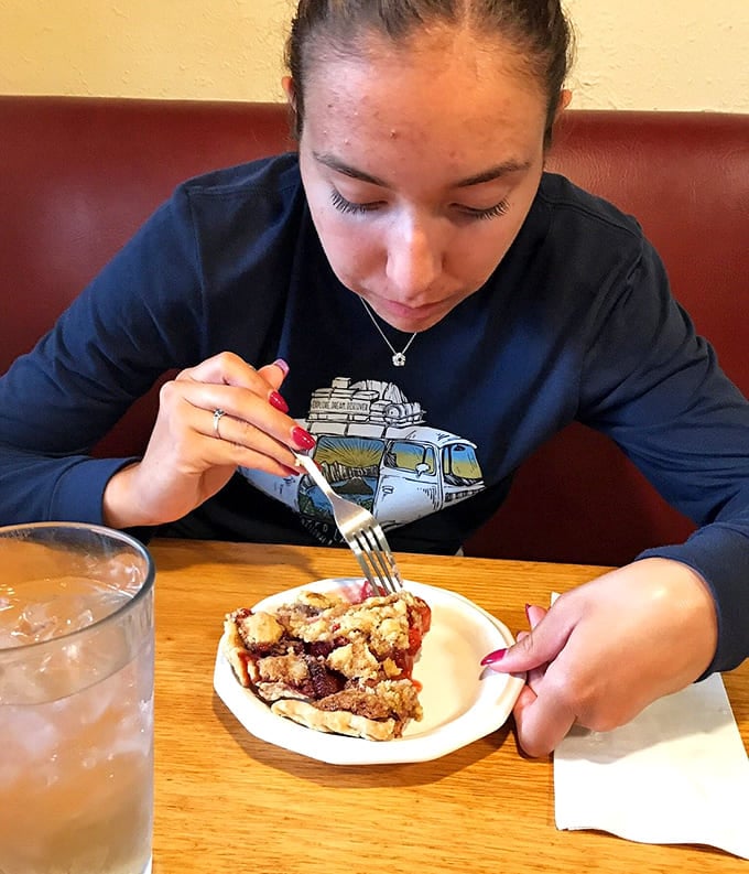 A young diner tackles her pie with the kind of focus that tells you it's absolutely worth the effort.