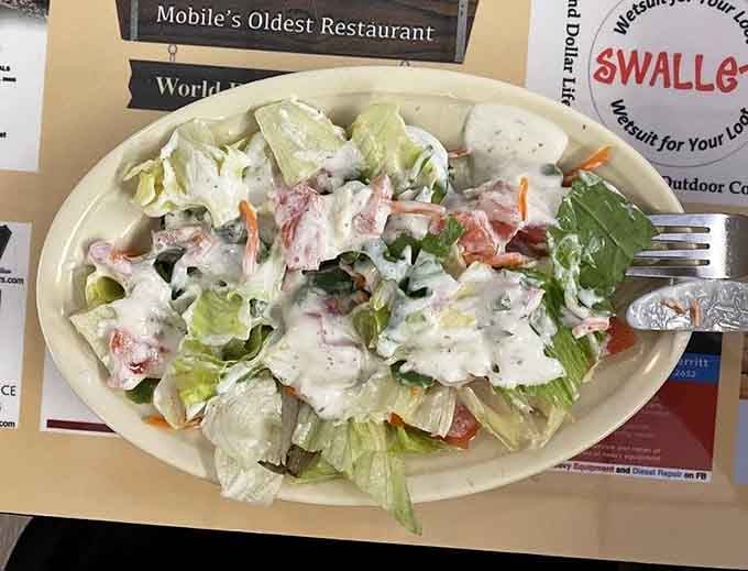 Fresh salad topped with shrimp and creamy dressing, because even comfort food joints understand balance and variety.