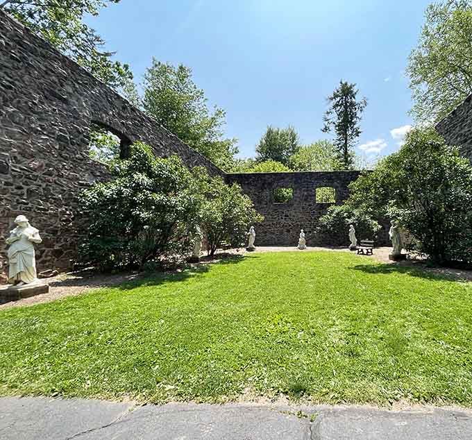 Classical statues standing guard in a stone courtyard, silently judging your hiking outfit choices with aristocratic disdain.