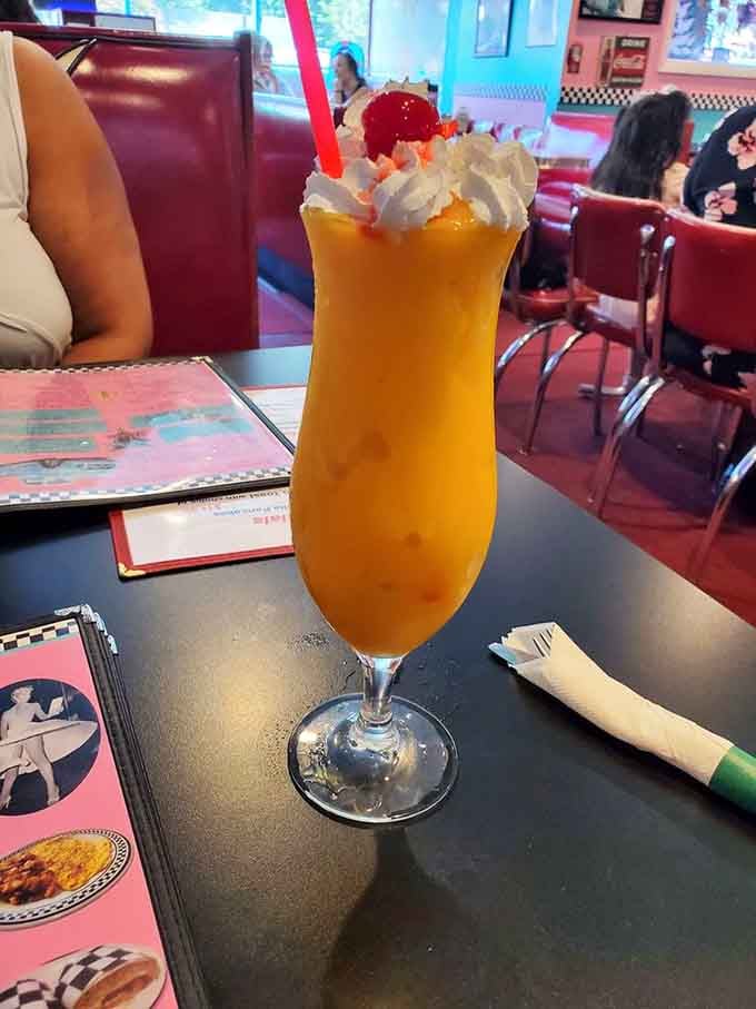 A bright orange smoothie topped with whipped cream and a cherry brings tropical vibes to this retro Connecticut spot.