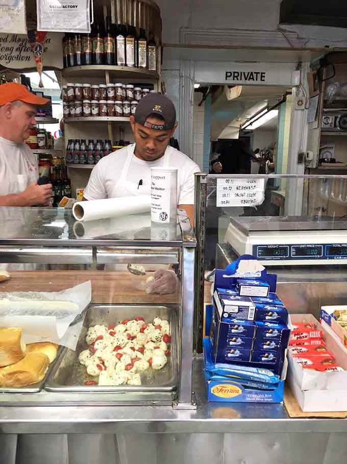 Behind this counter, sandwich artisans work faster than most people scroll through their phones at dinner.