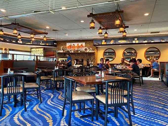 Spacious dining room with porthole windows and lighthouse art, nautical without being kitschy or overdone.