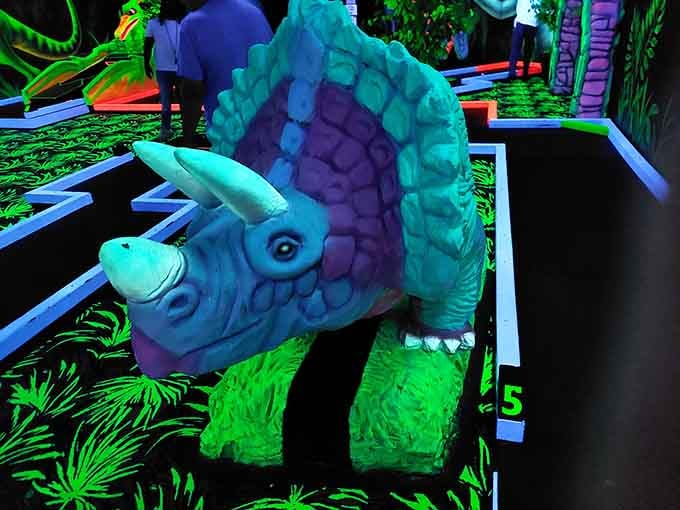 A triceratops stands frozen in electric blue glory, its prehistoric form reimagined as a guardian of this modern wonderland.