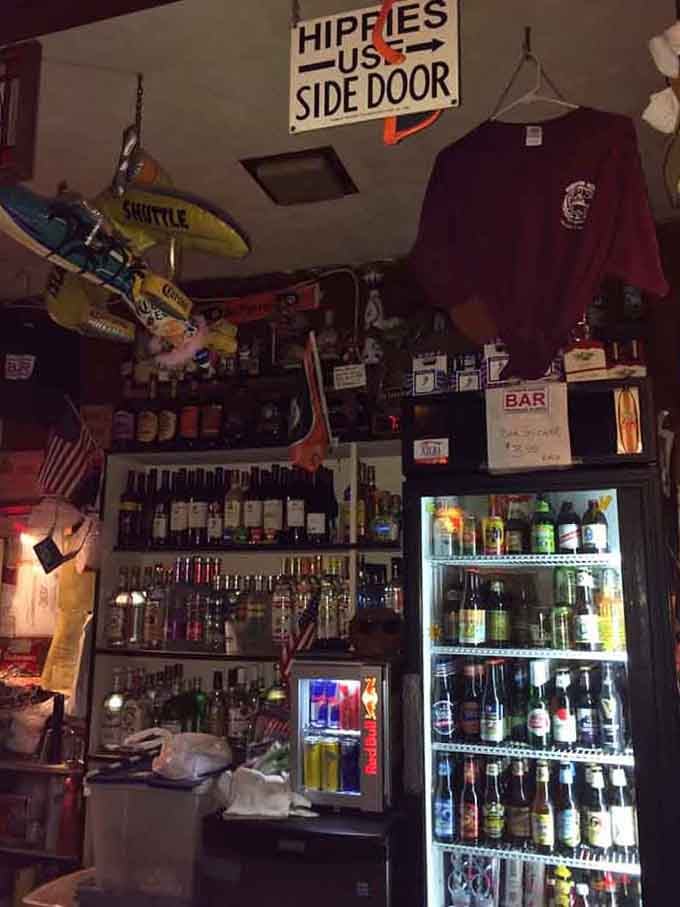 The bar's collection of spirits and random treasures, organized with a system only the bartender truly understands.