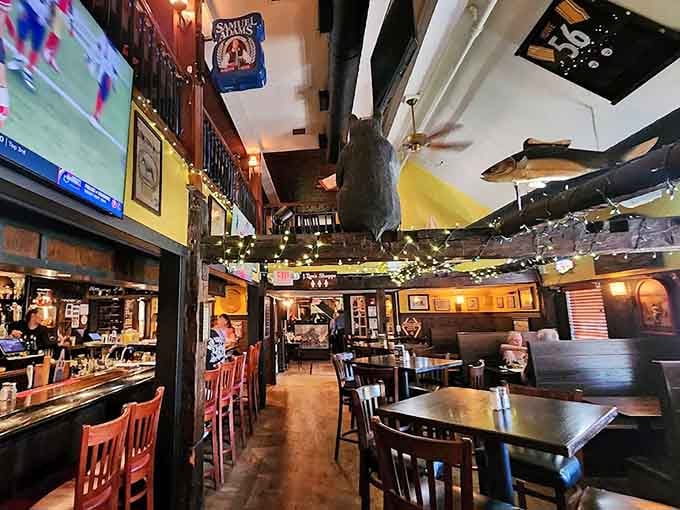 The interior blends rustic charm with modern comfort, where history meets hungry patrons under those magnificent beams.