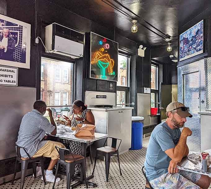 Diners savoring every bite while neon signs glow overhead, creating the kind of moment Norman Rockwell would paint today.