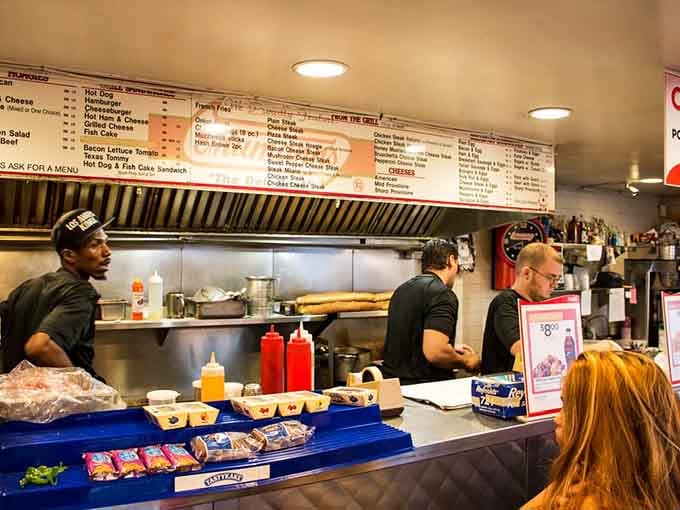 The crew behind the counter working with the efficiency of people who've made thousands of perfect sandwiches.
