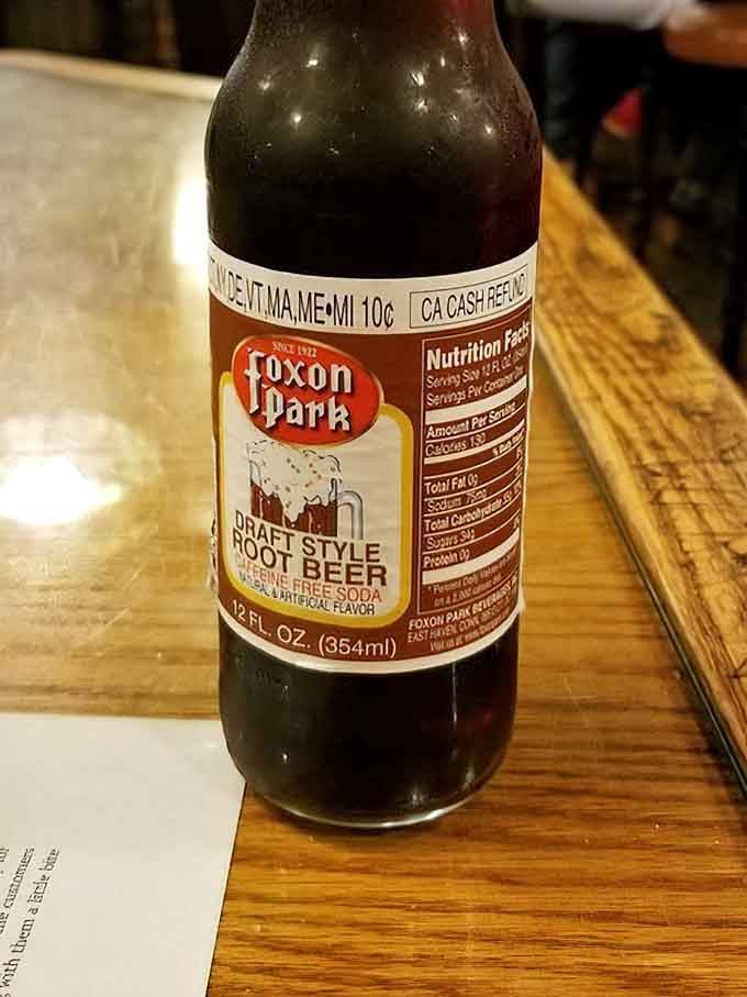 Draft-style root beer in glass bottles, because some traditions pair perfectly with the birthplace of American burger culture.