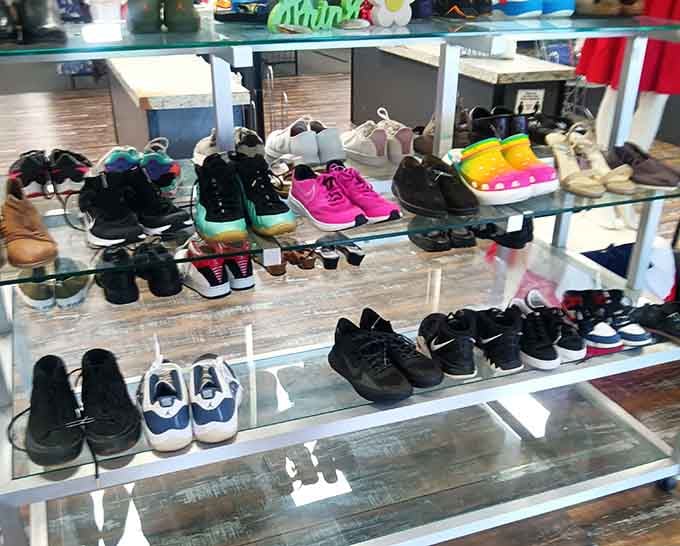 Shoes displayed on glass shelves like a boutique, proving secondhand footwear can look just as appealing as brand new kicks.