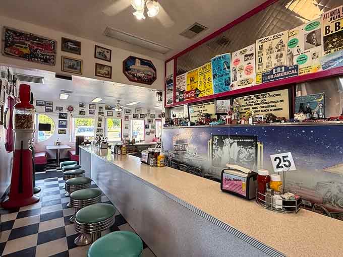 Counter seating with turquoise stools faces a mural of nighttime Americana, perfect for solo diners and people-watching enthusiasts.