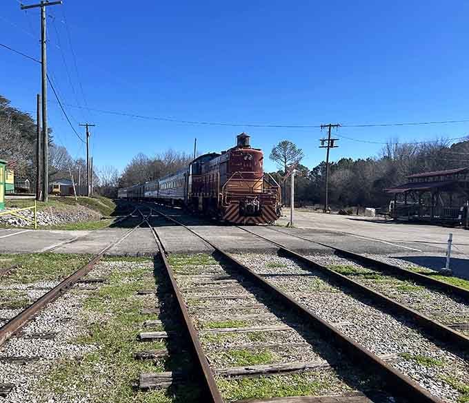 That red locomotive crossing the tracks is your reminder that some adventures require slowing down to appreciate fully.