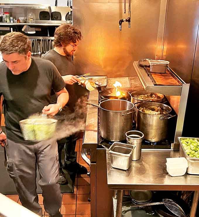 Behind the scenes, the kitchen team works their magic with flames and fresh ingredients in a well-orchestrated culinary ballet.