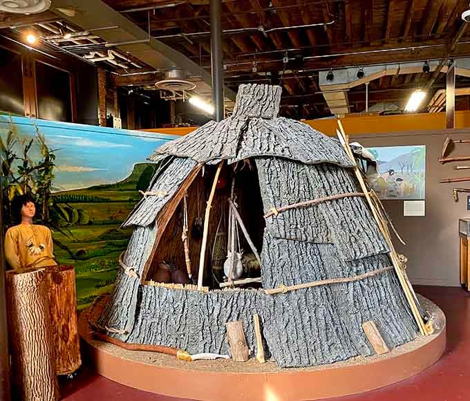 A Native American dwelling replica stands complete with period details, honoring the region's earliest inhabitants beautifully.