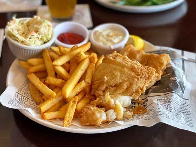 Golden fish and chips arrive with tartar sauce and coleslaw, honoring the British pub tradition with Connecticut execution.