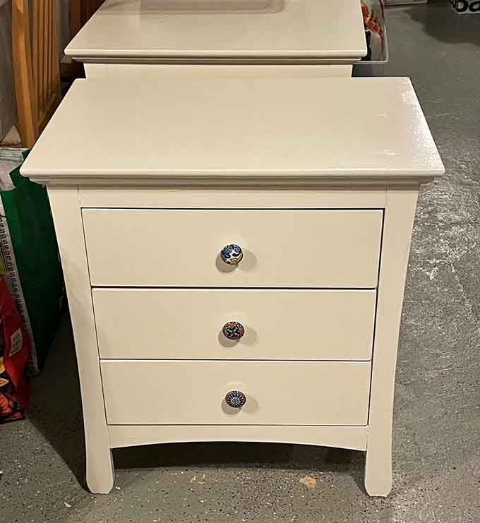 A pristine white nightstand sits ready to organize someone's bedside essentials, proving that gently used can look practically brand new.