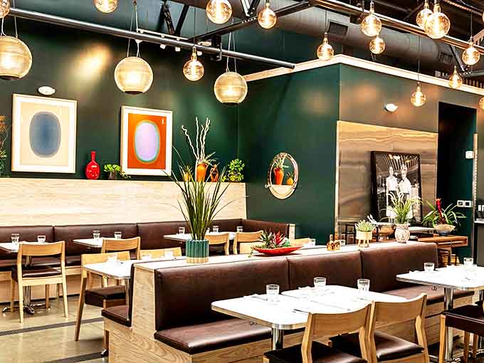 Globe lights and green walls create an ambiance that's both contemporary and comforting, like a hug with good taste.