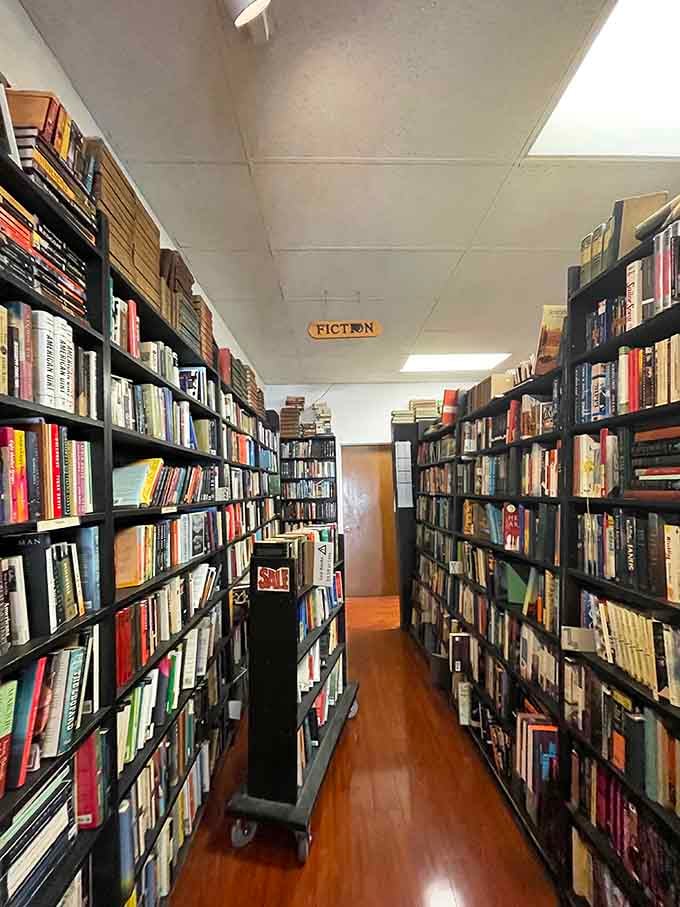 Fiction stretches toward the ceiling like literary skyscrapers, each level holding stories that could change your entire perspective tonight.