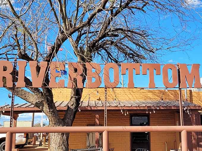 The River Bottom Bar & Grill's rustic wooden sign promises exactly what every traveler hopes to find—authentic local flavor with no pretension.