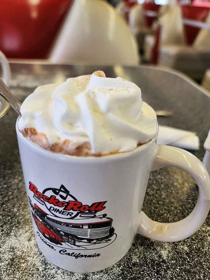 Hot chocolate topped with whipped cream in a souvenir mug, because some moments deserve extra sweetness and memories.