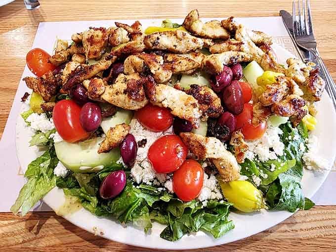 A Greek salad that's practically a Mediterranean vacation on a plate, with olives playing hide-and-seek among the greens.