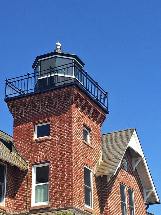 The square tower rises above the roofline, defying every round lighthouse stereotype with Victorian confidence and style.