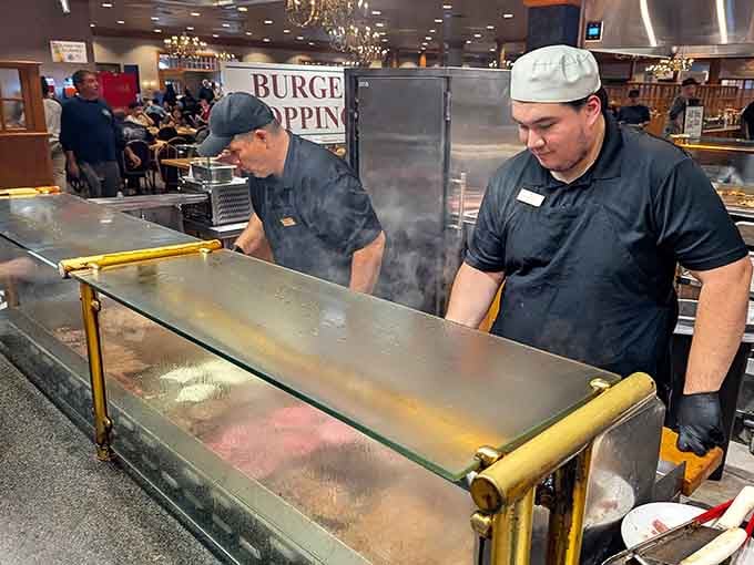 The grill masters work their magic behind protective glass, turning raw ingredients into sizzling works of edible art.