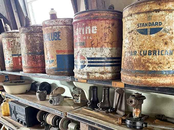 Old oil cans lined up like soldiers, their weathered labels telling stories of brands and designs long since forgotten.