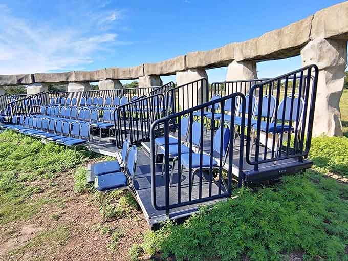 Blue amphitheater seating faces the stones, where performances meet prehistoric ambiance in unexpected harmony throughout the year.