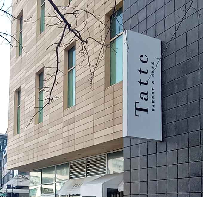 The vertical signage announces your destination like a beacon for anyone craving authentic European-style caf&eacute; culture in Cambridge.