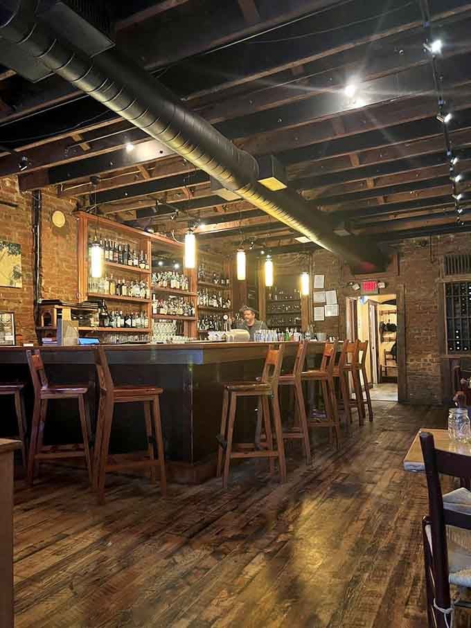 A well-stocked bar with exposed brick and warm wood creates the perfect spot for pre-dinner drinks or post-work unwinding.