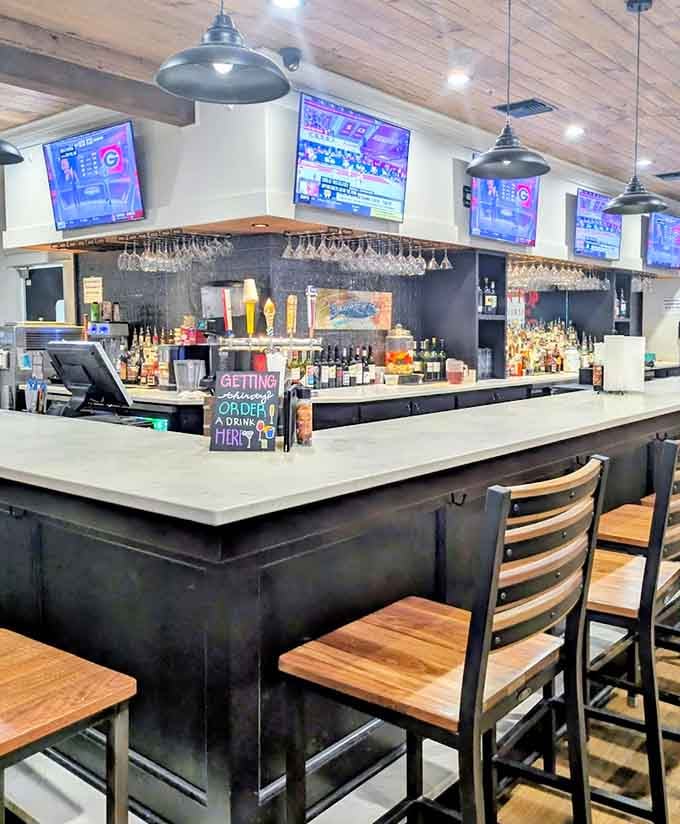 The bar area gleams with promise, where cold drinks and warm hospitality meet under industrial pendant lights.