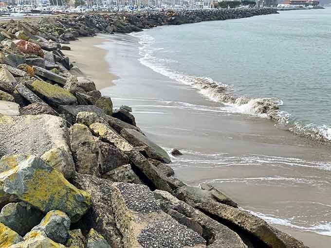 The rocky jetty extends into calm waters, offering peaceful views and the gentle soundtrack of lapping waves.