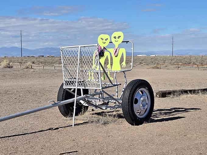 Two alien friends hitching a ride on a desert trailer, patiently waiting for their mothership's Uber rating.