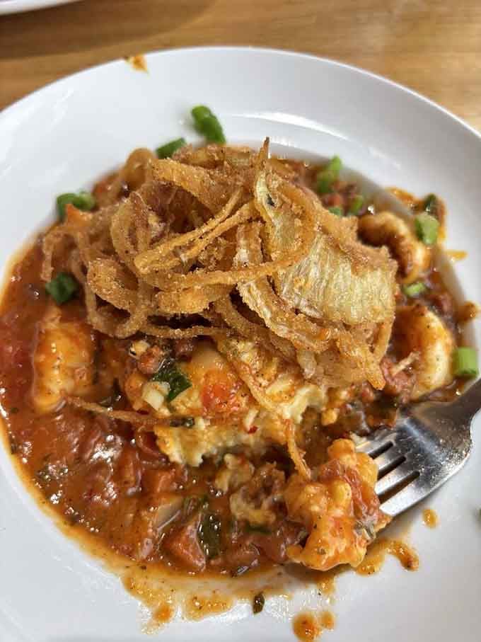 Wild shrimp nestled in creamy grits with crispy onions on top, because the South knows what it's doing.