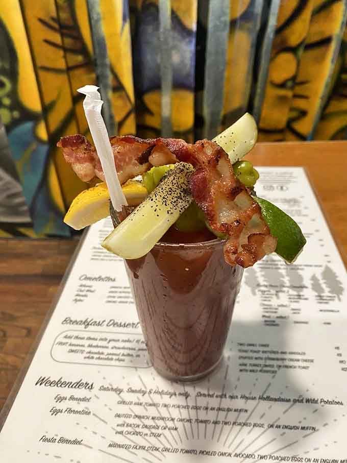 A Bloody Mary garnished with bacon and pickles stands ready to make your weekend brunch feel like the celebration it deserves.