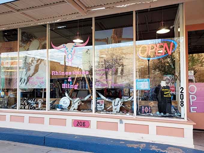 That whimsical window display with its rhinestone cowboy skull proves small-town shops have personality that chain stores can't replicate.