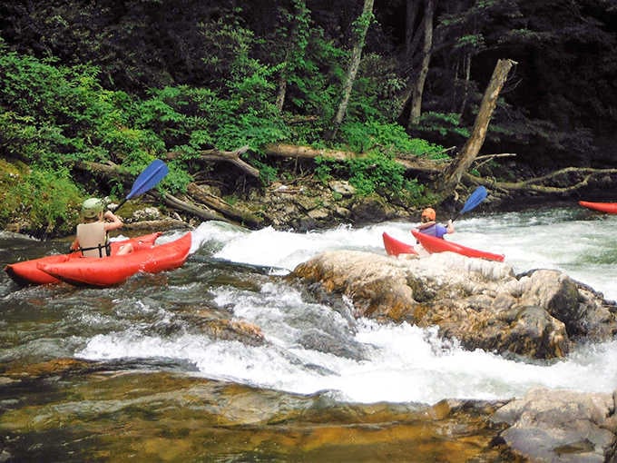 Kayakers navigate the gentle rapids of the North Toe River, finding that perfect balance between adventure and the serenity of nature.