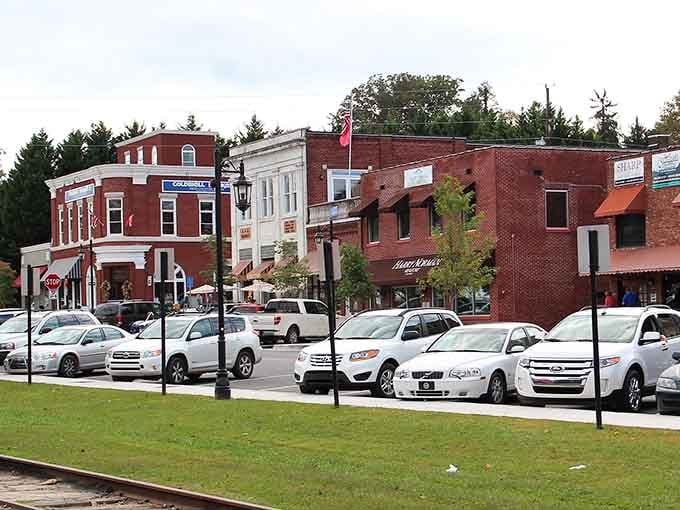 Red brick storefronts march up the street toward pine-covered mountains, blending commerce with natural beauty seamlessly.