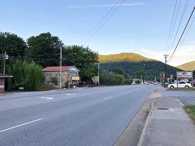 Maggie Valley's scenic highway stretches toward adventure with the Blue Ridge Mountains standing guard like ancient sentinels.