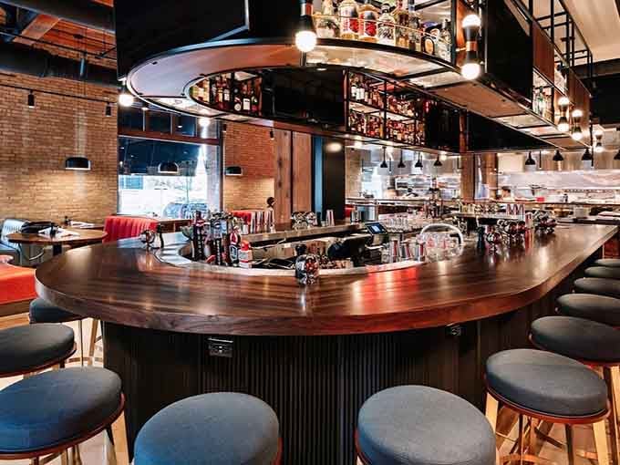 A circular bar that invites lingering, laughing, and probably ordering one more bacon flight for the table.