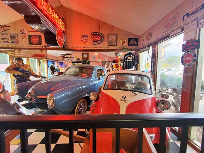 Classic cars perched above the dining area, because apparently someone decided eating needed more horsepower and style.