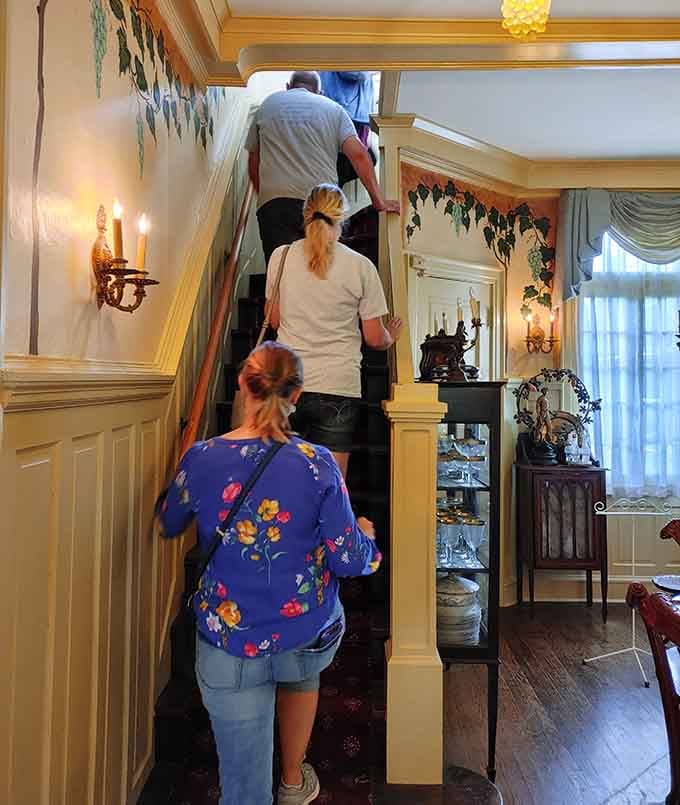 Tourists climbing stairs like they're entering Narnia, except this wardrobe is an entire Victorian mansion instead.