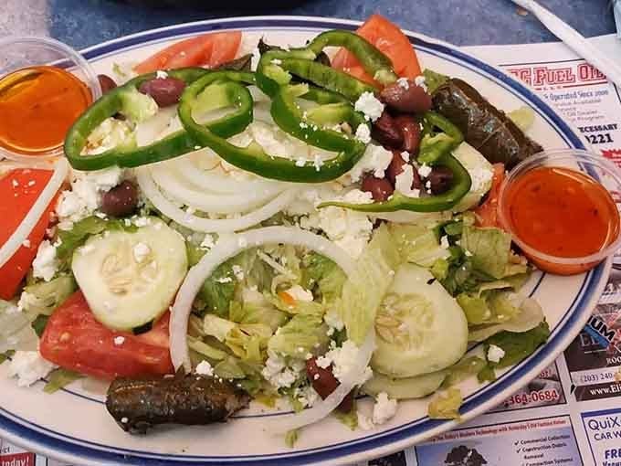 Greek salad loaded with feta, olives, and enough fresh vegetables to justify ordering that apple turnover afterward.