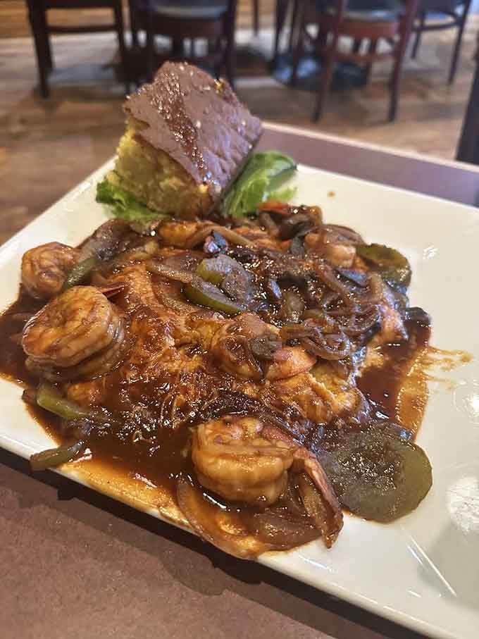 Shrimp and grits swimming in rich gravy with peppers and onions, proving Southern comfort food is basically edible happiness.