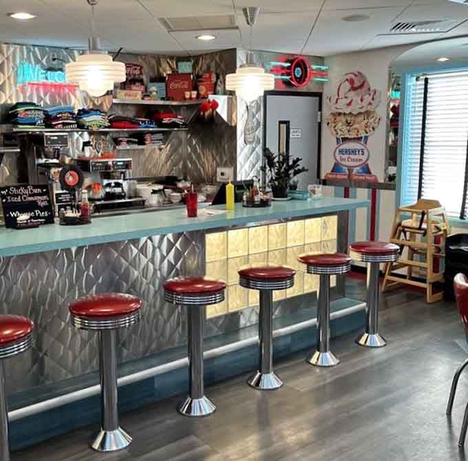 Counter seating with chrome stools lets solo diners enjoy the show while the kitchen works its morning magic.