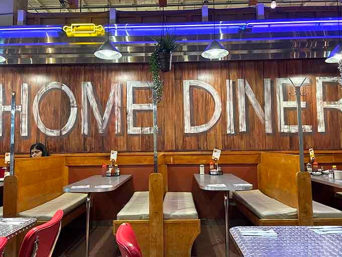 Cozy booths beneath that massive wooden sign provide the perfect spot for lingering over comfort food classics.