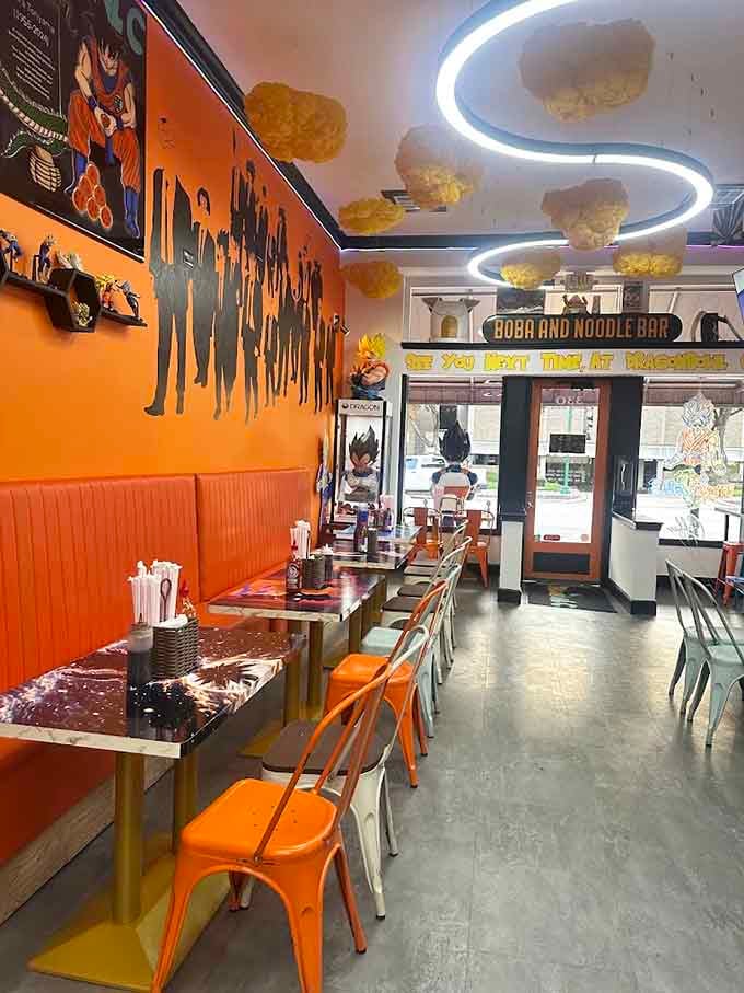 Booth seating with character silhouettes on orange walls, cloud-like ceiling decorations, dining here feels like an animated adventure itself.